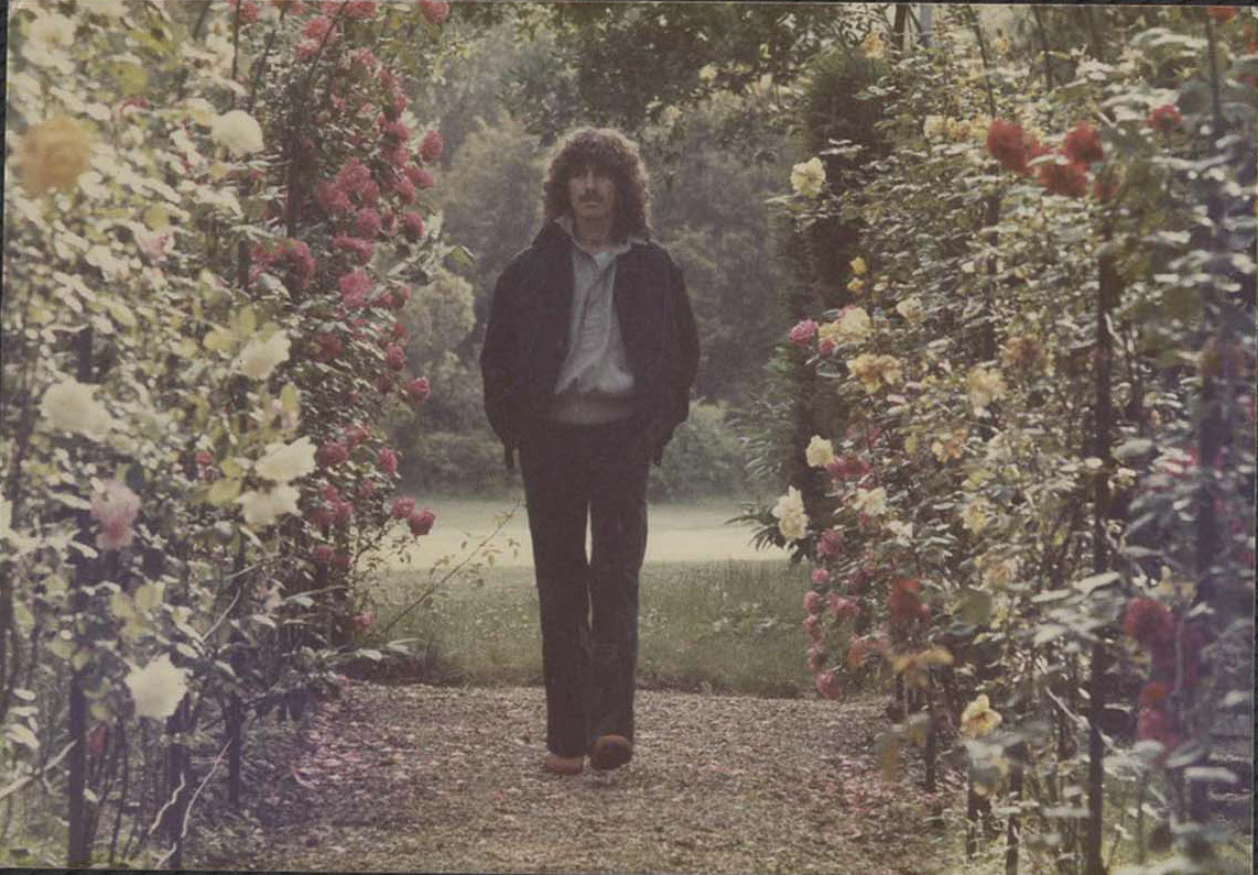 George pictured in a garden on the grounds - The Beatles